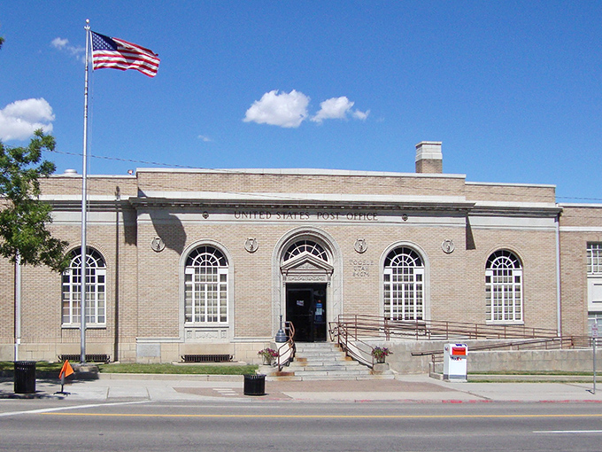 The historic Tooele Post Office stands proudly under blue skies, a brick sentinel that's witnessed generations of community news and gossip.