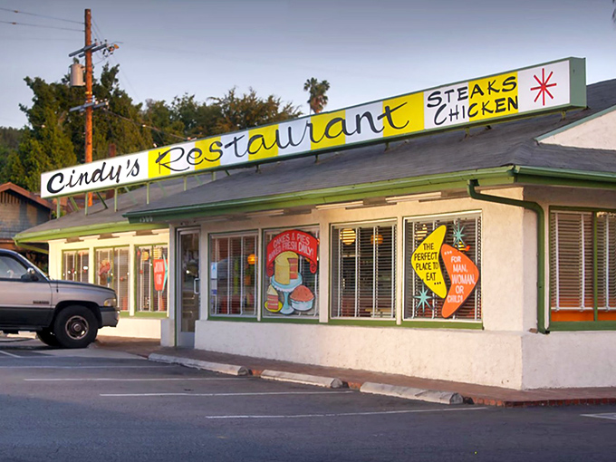 The sunshine-yellow facade of Cindy's Diner promises retro comfort before you even step inside. California palm trees and classic signage complete the time-travel experience.