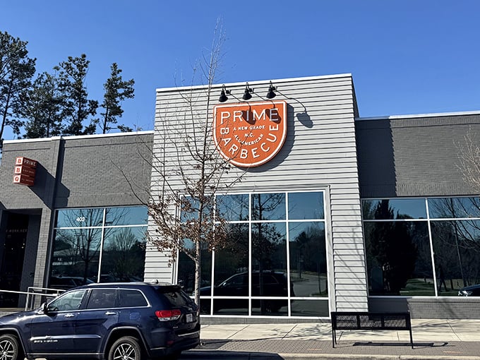 The modern exterior of Prime Barbecue stands like a beacon of hope for hungry travelers. That orange sign promises smoky salvation just beyond those doors.