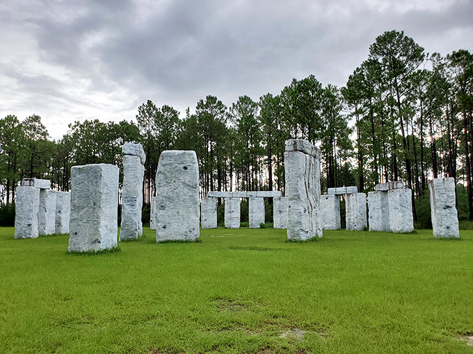 Stonehenge meets Sweet Home Alabama in this surreal fiberglass replica. The massive white monoliths create a striking contrast against the emerald grass and towering pines.