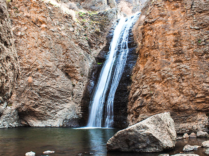 Nature's perfect frame &ndash; rugged canyon walls showcase the 60-foot cascade as it plunges into a serene pool below.