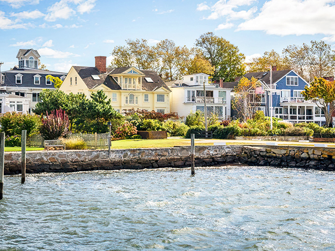 Colorful coastal homes line the harbor like a welcoming committee, their gardens spilling toward stone seawalls where the land surrenders gracefully to the Atlantic.
