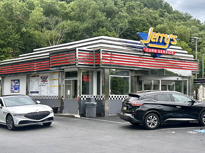 The gleaming chrome and red-striped exterior of Jerry's Curb Service stands like a time capsule from the golden age of American drive-ins, beckoning hungry travelers with nostalgic charm.