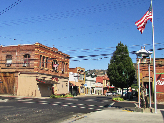 Historic brick buildings line Yreka's main street, where the American flag stands proudly against a perfect blue sky. Small-town Americana at its most authentic.