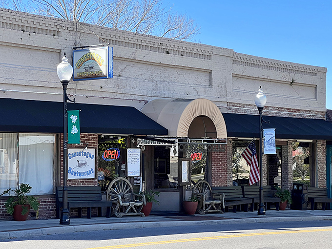 The historic facade of Conestogas Restaurant stands as a welcoming beacon on Alachua's Main Street, complete with wagon wheels that hint at the Western-themed delights waiting inside.