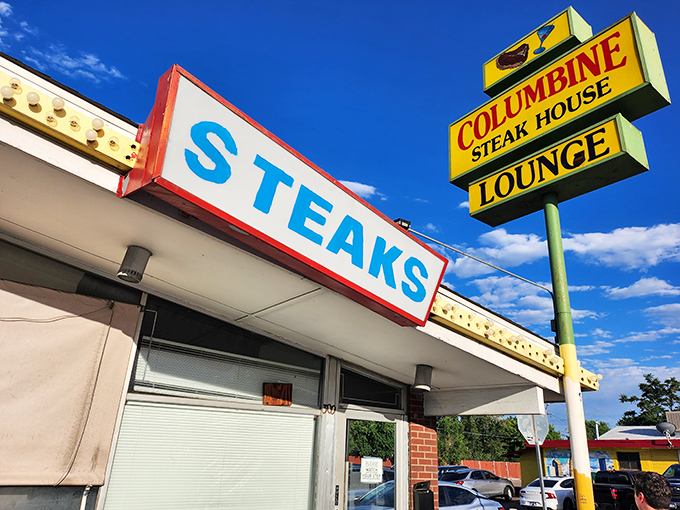 The iconic Columbine sign stands tall against Colorado's blue sky, a beacon of hope for hungry carnivores since 1961. No frills, just thrills.