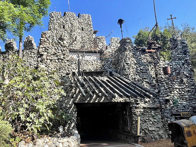 The grand entrance to Rubel Castle looks like what would happen if medieval knights raided a quarry. Stone walls reach skyward under California's perfect blue.
