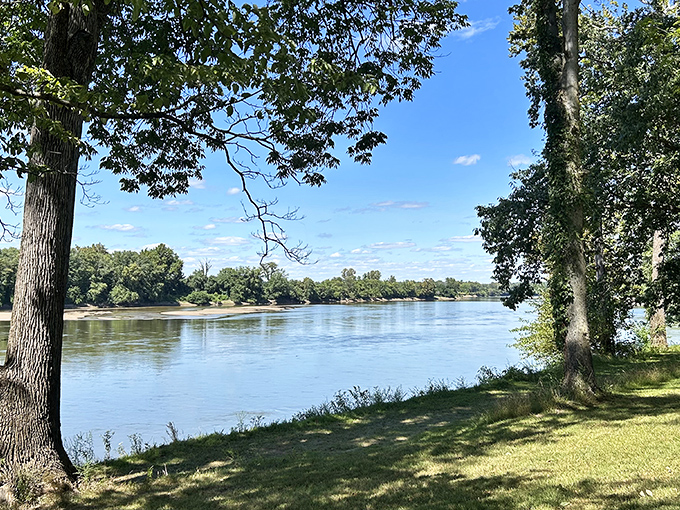 The Wabash River flows with quiet confidence, framed by ancient trees that have witnessed centuries of Indiana history.