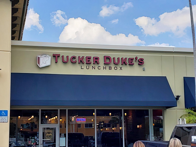 The iconic blue awning and bold red signage of Tucker Duke's beckons like a lighthouse for burger enthusiasts navigating the seas of mediocre fast food options.