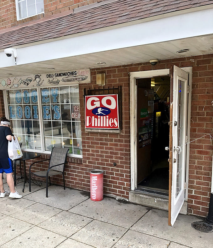 The unassuming brick storefront of Gooey Looies, where Philadelphia's cheesesteak dreams come true without the tourist fanfare. That "Go Phillies" sign says it all&mdash;authentic Philly through and through.