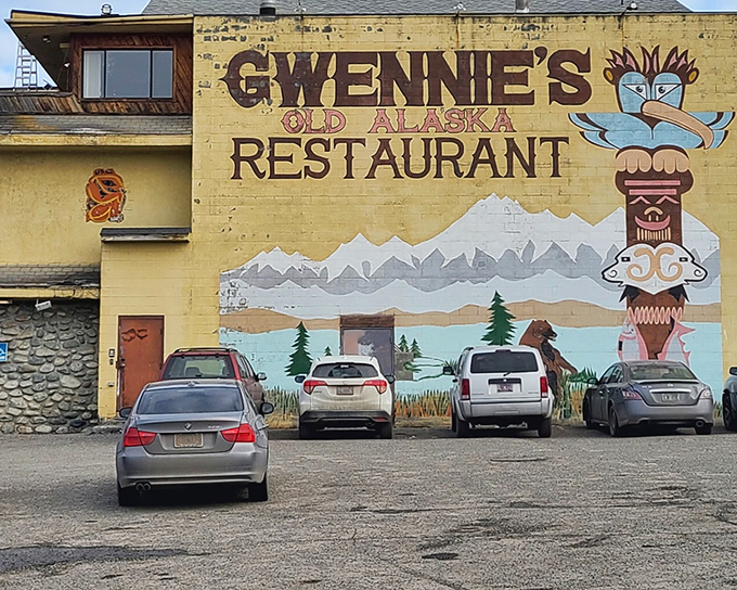 The unmistakable yellow exterior of Gwennie's, with its hand-painted totem pole and mountain scene, promises authentic Alaskan comfort within.