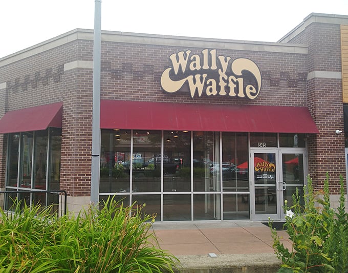 The iconic Wally Waffle sign beckons breakfast enthusiasts like a yellow brick road leading to the promised land of perfect pancakes.