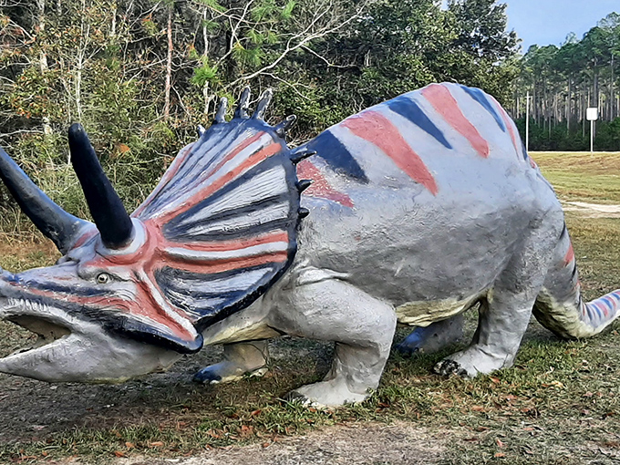 The Triceratops stands proudly in the Alabama sunshine, its red and white paint job suggesting it might moonlight as a candy cane during the holidays.
