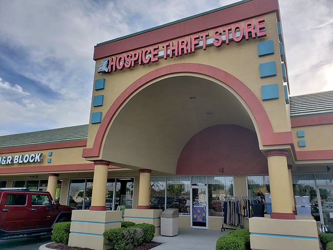 The pink-accented facade of Hospice Thrift Store stands like a portal to bargain heaven, beckoning treasure hunters with promises of undiscovered gems inside.