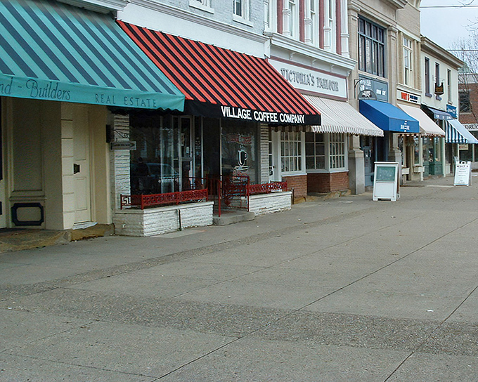 Colorful awnings march down Broadway like a parade of candy-striped promises, each storefront whispering "come explore me."