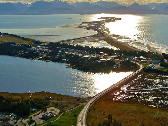 The Homer Spit stretches into Kachemak Bay like nature's own welcome mat, with mountains standing guard across the water.