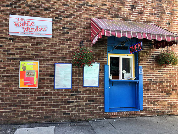 Simplicity at its most delicious: a bright blue window, a striped awning, and menus promising waffle creations that will haunt your dreams in the best possible way.
