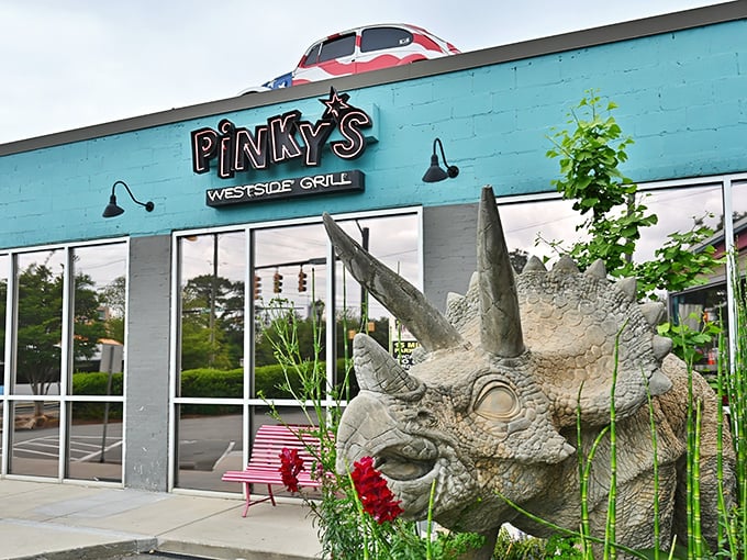 That's not a mirage – it's a patriotic VW Bug perched atop a turquoise diner with a dinosaur standing guard. Charlotte's quirkiest welcome committee!