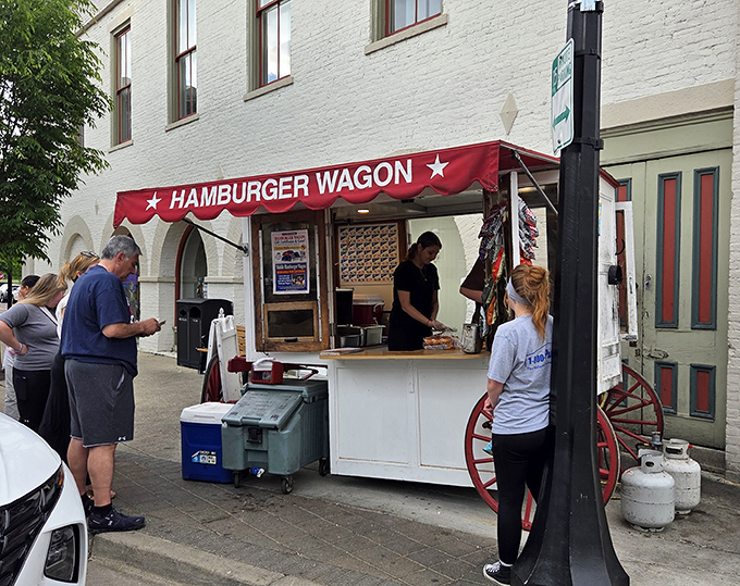 The iconic red awning of Hamburger Wagon stands like a culinary lighthouse on Miamisburg's brick streets, beckoning hungry pilgrims to its simple yet legendary offerings.