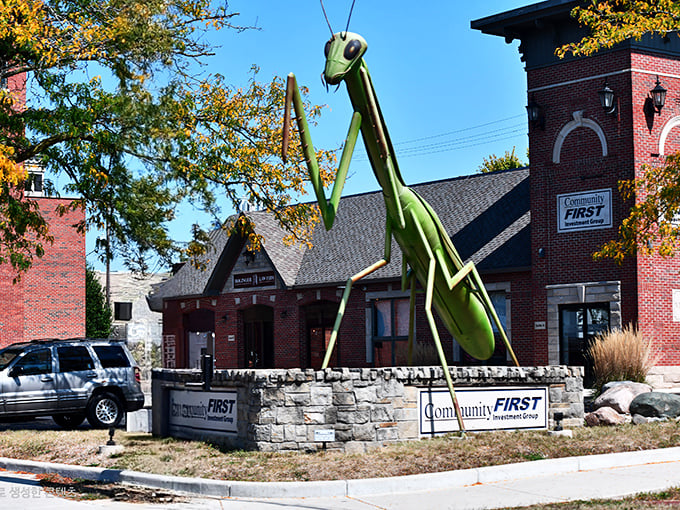 The lime-green guardian of Kokomo stands tall against the brick backdrop, like a prehistoric sentry keeping watch over downtown.