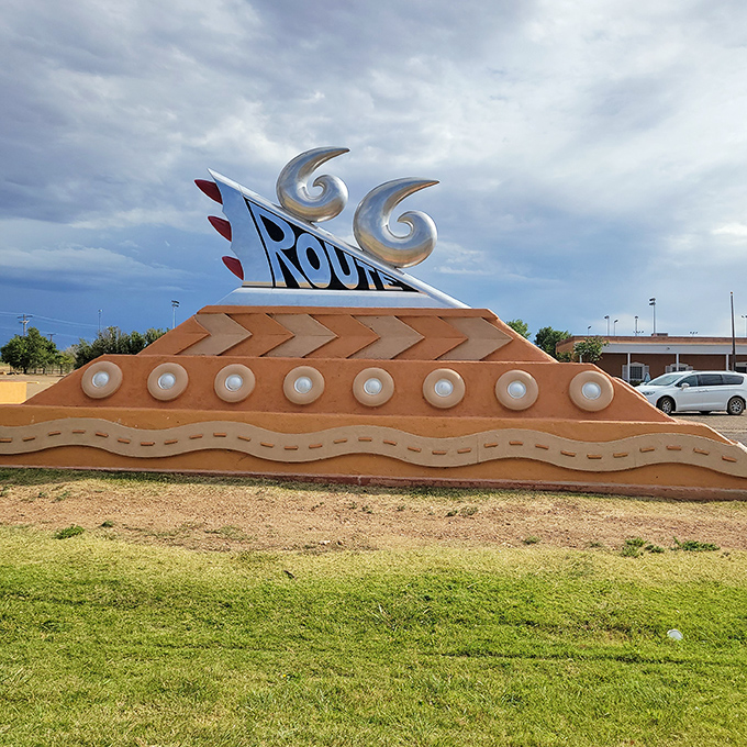 The Route 66 Monument gleams against moody New Mexico skies, like a chrome-finned time machine beckoning road trippers.