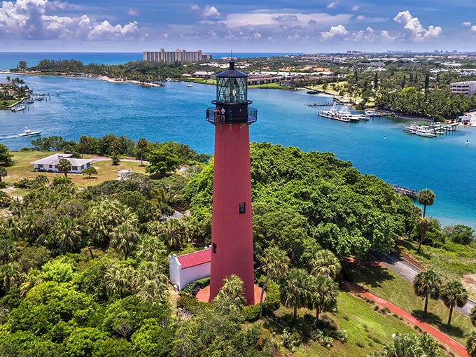 Like a crimson sentinel rising from an emerald island, Jupiter Inlet Lighthouse stands watch where the Loxahatchee River meets the Atlantic, painting the perfect Florida postcard.