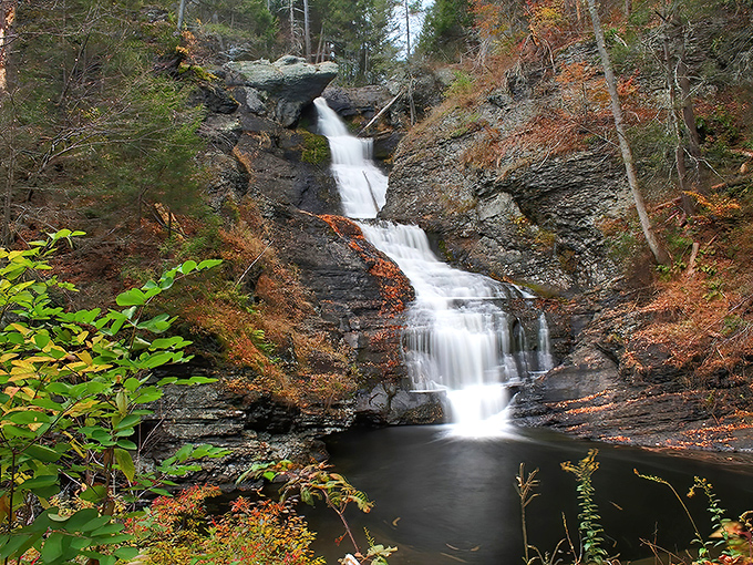 Fall foliage frames the cascading waters like nature's own picture frame. Mother Nature showing off her watercolor skills in Pennsylvania.
