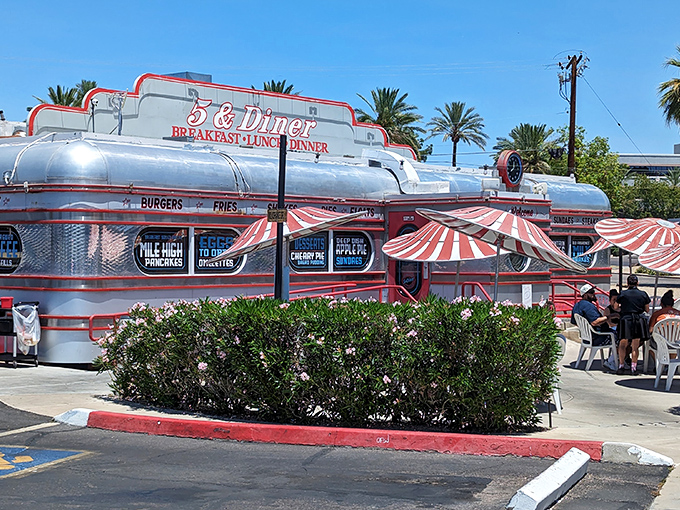 The gleaming chrome exterior of 5 & Diner shines like a beacon of nostalgia, its red and white stripes promising a time-traveling culinary adventure in the Arizona sun.
