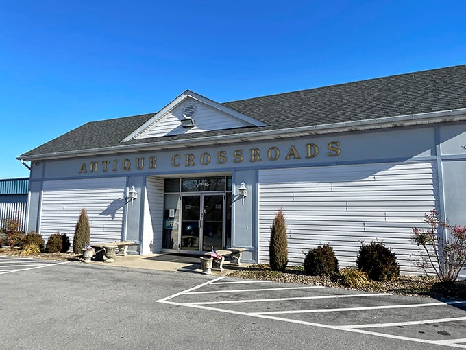 The white facade of Antique Crossroads stands like a temple to nostalgia under Maryland's blue skies, promising treasures within its unassuming walls.