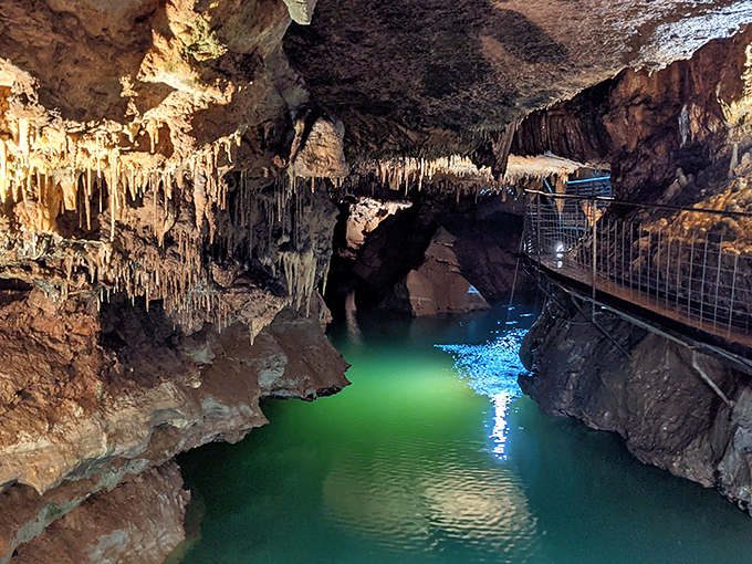 Nature's light show illuminates this emerald underground lake, where stalactites have been perfecting their downward dance for millennia.
