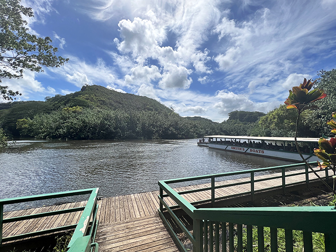 A wooden dock welcomes river explorers to Wailua's emerald waters, where adventure floats by on gentle currents.