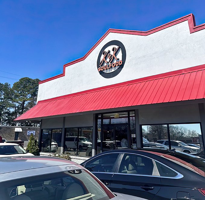The iconic red-trimmed exterior of K&K Soul Food stands like a beacon of culinary promise against the Atlanta sky. Soul food salvation awaits inside.