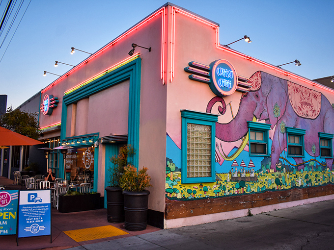 As evening falls, Crest Cafe's neon lights and colorful facade transform the breakfast haven into a glowing landmark in San Diego's vibrant dining scene.