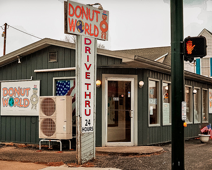 The unassuming green exterior of Donut World, with its vintage sign promising "DRIVE THRU 24 HOURS," stands as a beacon of hope for donut enthusiasts at any hour.