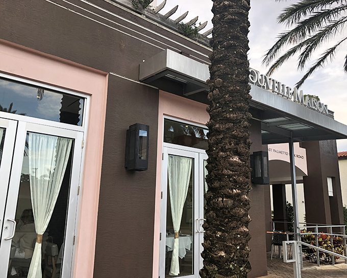 La Nouvelle Maison's elegant pink exterior whispers "come inside" while the palm trees remind you you're still in Florida. Parisian charm meets Boca Raton sunshine.