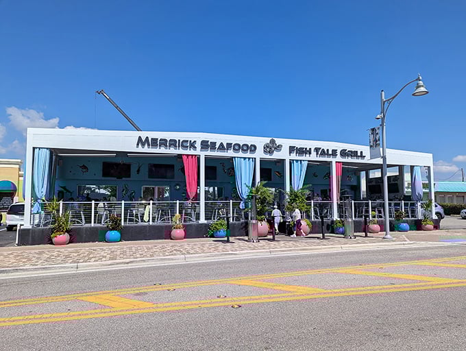 The pristine white exterior of Fish Tale Grill beckons like a culinary lighthouse on Cape Coral's shoreline, complete with colorful planters that say "Yes, vacation starts here."