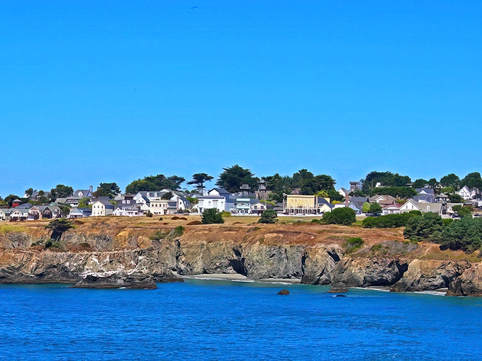 Mendocino perches dramatically on rugged cliffs, its white Victorian homes standing sentinel above the deep blue Pacific like a New England village that took a wrong turn and found paradise.