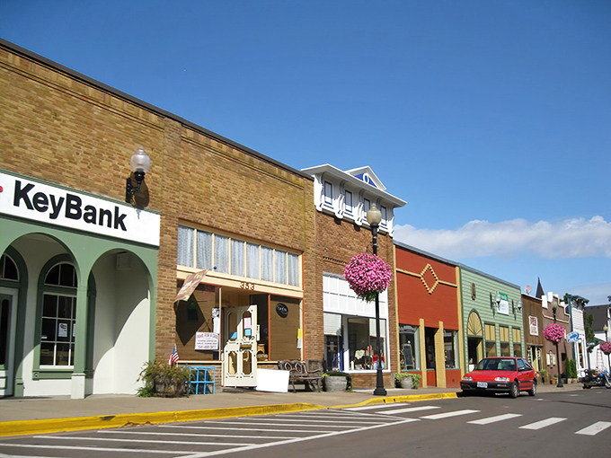 Downtown Brownsville's colorful storefronts pop against blue skies, where hanging flower baskets add splashes of joy to every corner.