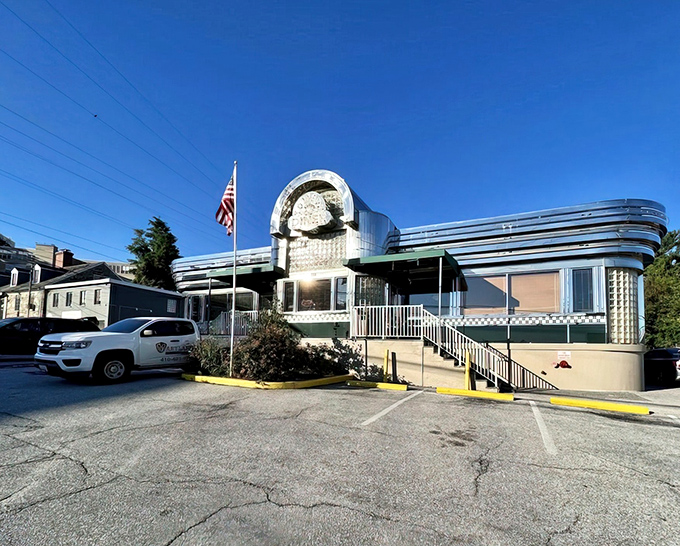 The gleaming stainless steel exterior of Towson Diner stands like a time capsule from America's golden age, complete with patriotic flag and welcoming entrance steps.