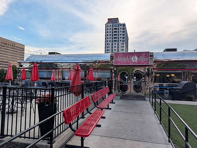 The gleaming silver exterior of Midnight Diner stands like a time capsule in Charlotte's urban landscape, complete with those signature red umbrellas promising shelter for hungry souls.