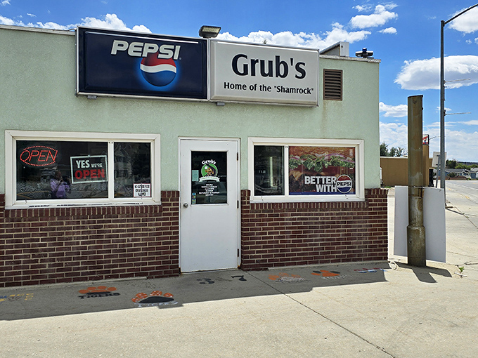 The unassuming mint-green exterior of Grub's Drive-In stands as a time capsule of Americana, promising burger perfection behind that humble facade.