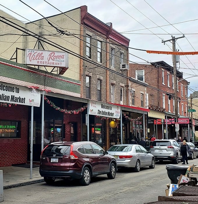The iconic Villa di Roma sign stands proudly in Philly's Italian Market, a beacon of red-sauce salvation amid the bustling street scene.
