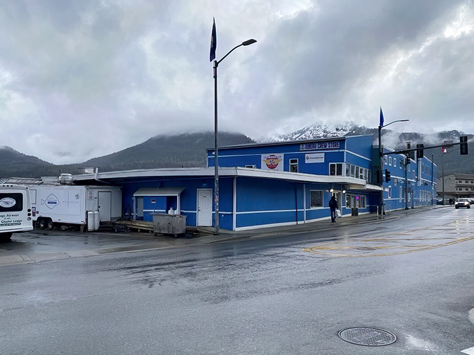 The bright blue exterior of The Hangar on the Wharf stands defiant against Juneau's moody skies, like a culinary lighthouse beckoning hungry travelers.