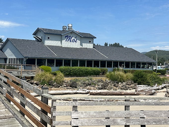 Mo's iconic white clapboard exterior stands like a coastal sentinel, promising seafood treasures within. The blue sign has guided hungry travelers for generations.
