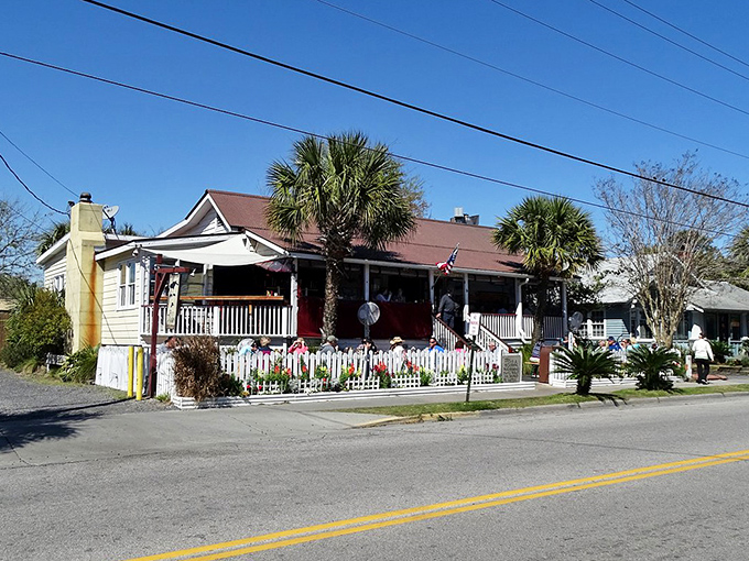 The charming cottage exterior of Poe's Tavern stands proudly on Middle Street, its wraparound porch practically whispering "come sit a spell" to passersby.