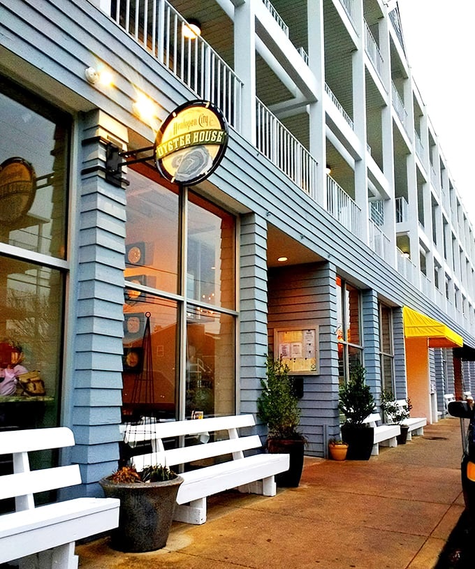 Coastal charm meets urban sophistication with the restaurant's welcoming exterior, where white benches invite you to pause before diving into oceanic delights.