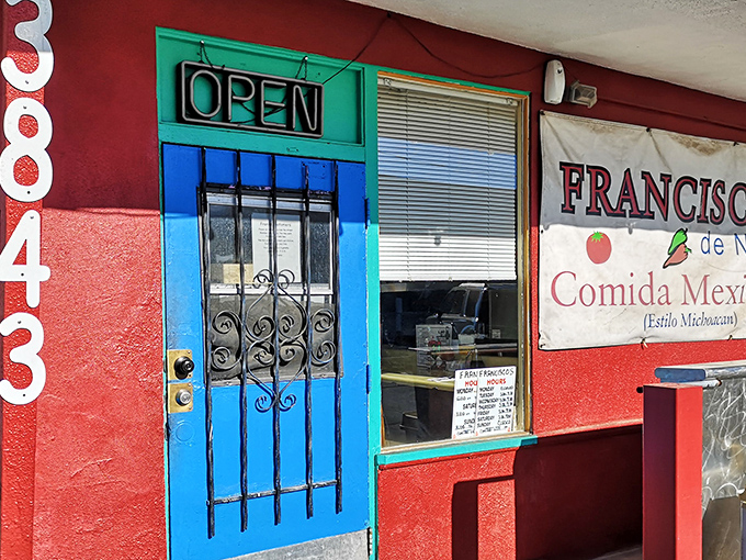 The vibrant red exterior with its turquoise blue door isn't just eye-catching&mdash;it's practically screaming "authentic neighborhood gem" in architectural form.