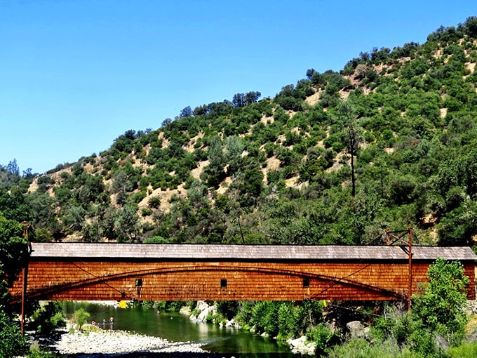 The honey-amber hues of Bridgeport Covered Bridge glow in the California sunshine, spanning the crystal-clear South Yuba River like a postcard come to life.