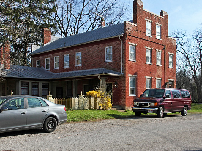 This stately brick residence could be a movie set for a period drama, complete with white picket fence and the kind of porch made for Sunday lemonade.