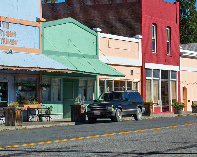 The Dutchman Restaurant's blue facade stands out like a sapphire in this colorful row of historic buildings, promising comfort food with small-town flair.